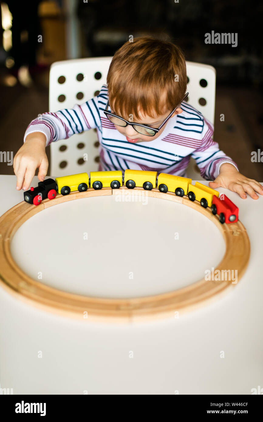 little ginger boy with glasses with syndrome dawn playing with lego ...