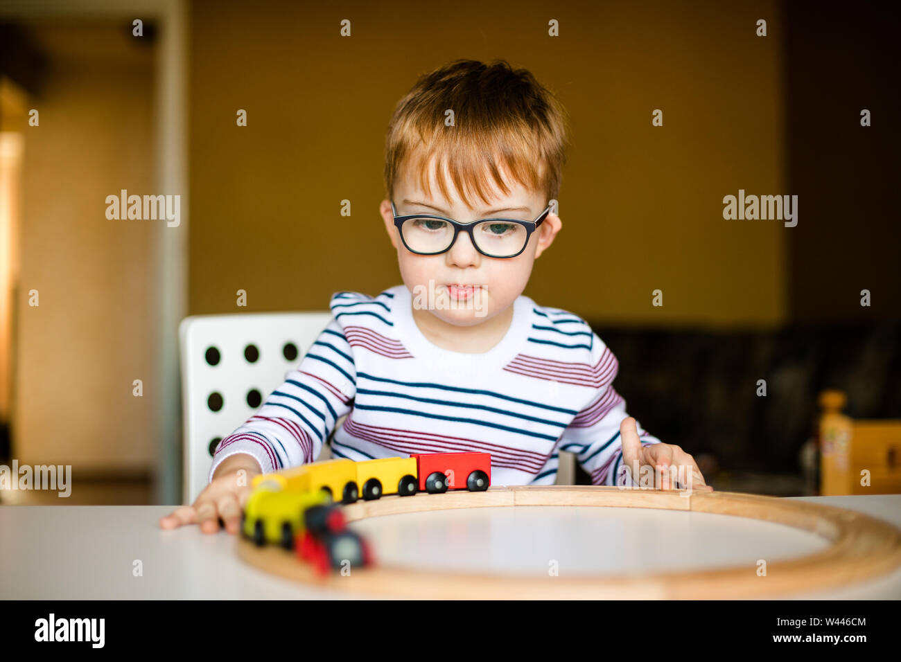 little ginger boy with glasses with syndrome dawn playing with train ...