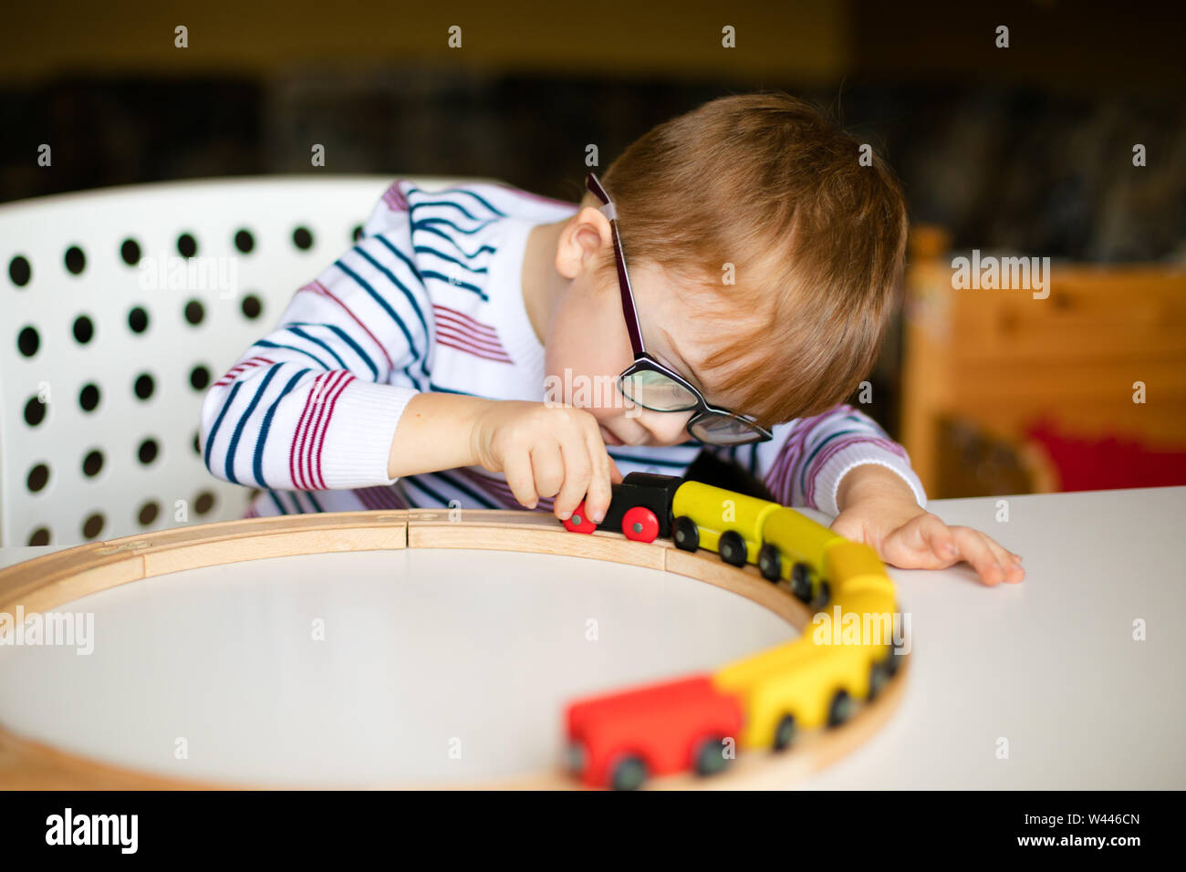 little ginger boy with glasses with syndrome dawn playing with train ...