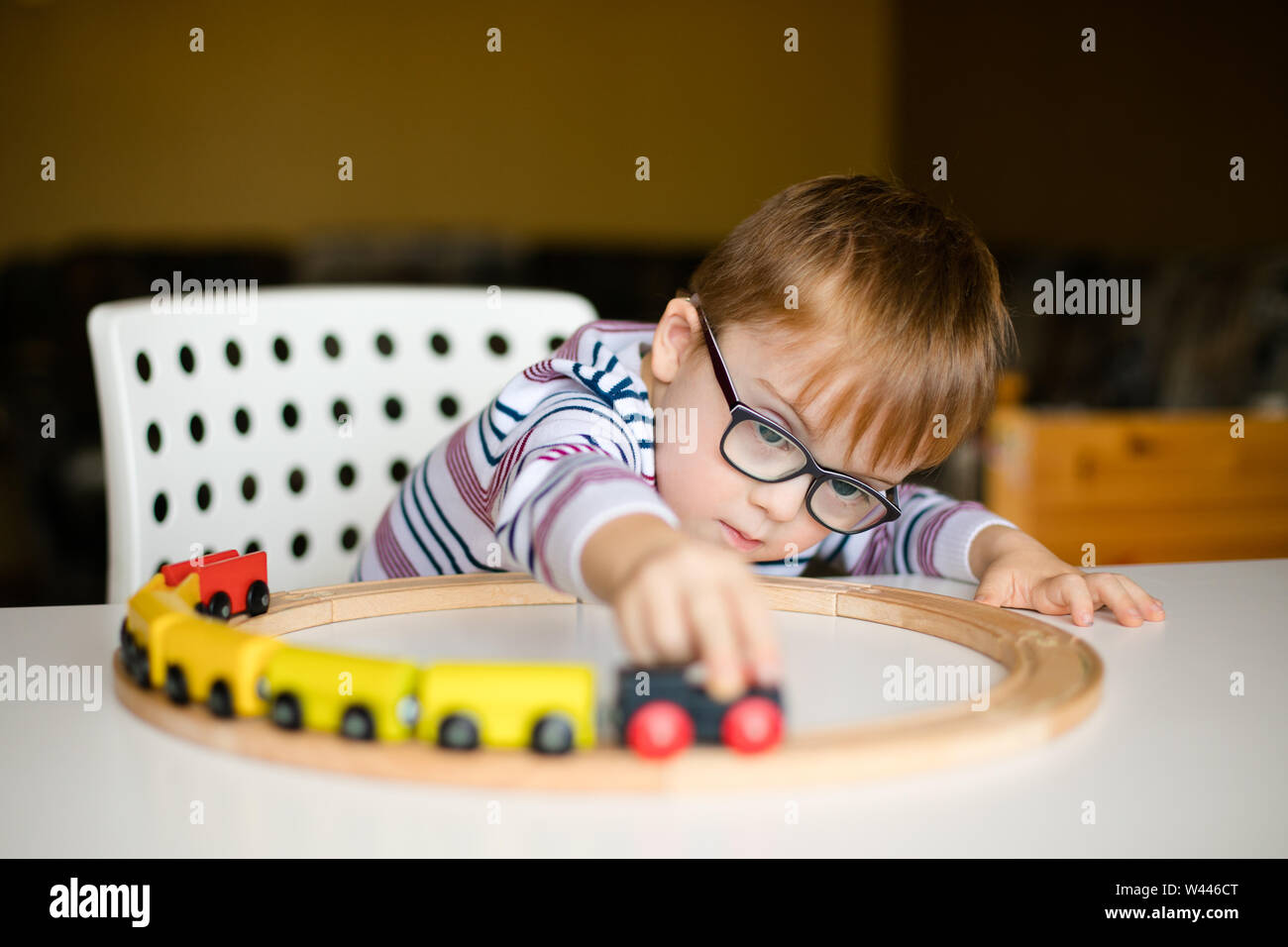 little ginger boy with glasses with syndrome dawn playing with train ...