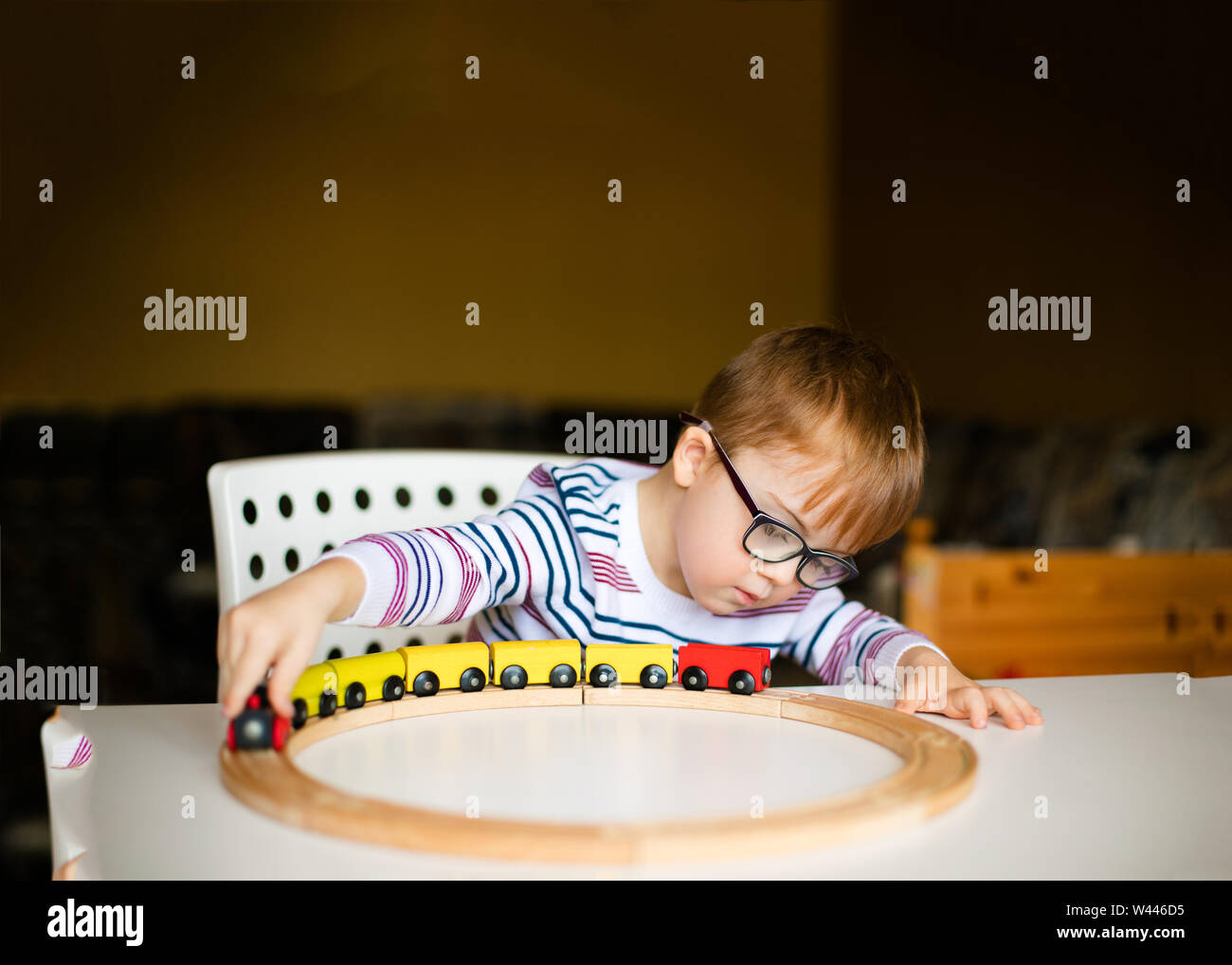 little ginger boy with glasses with syndrome dawn playing with train ...