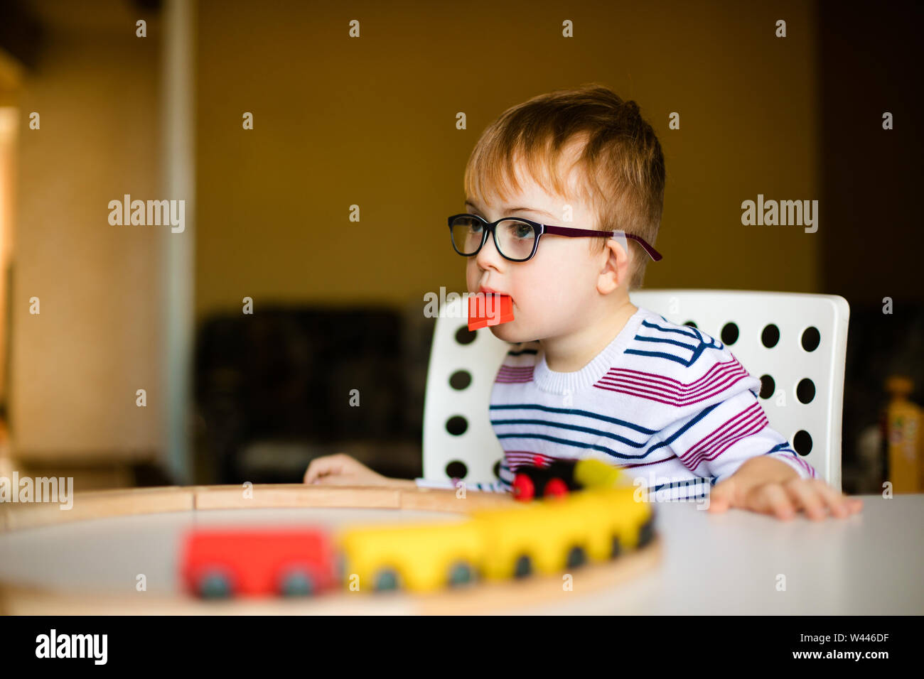 little ginger boy with glasses with syndrome dawn playing with train ...