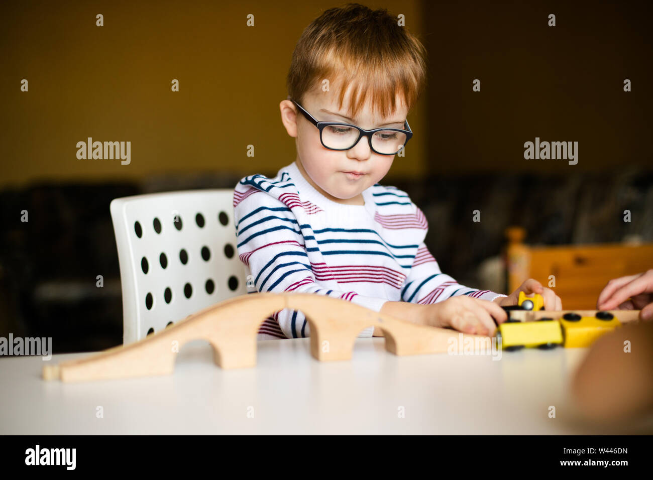 little ginger boy with glasses with syndrome dawn playing with train ...