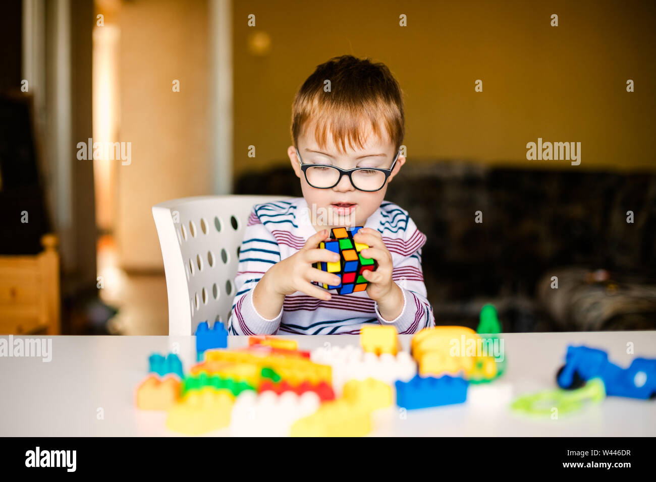 little ginger boy with glasses with syndrome dawn playing with color ...