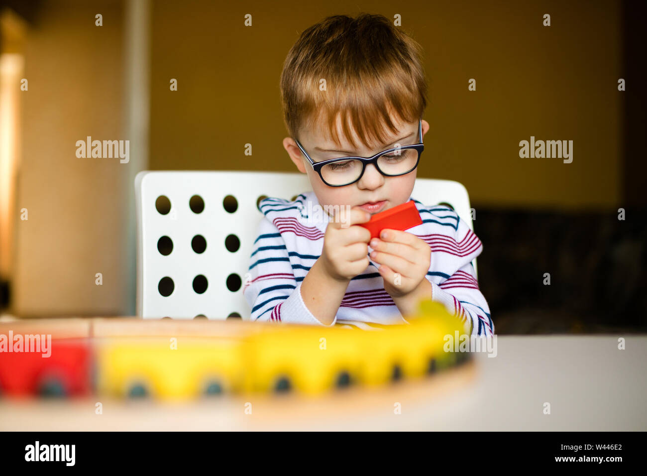 little ginger boy with glasses with syndrome dawn playing with train ...