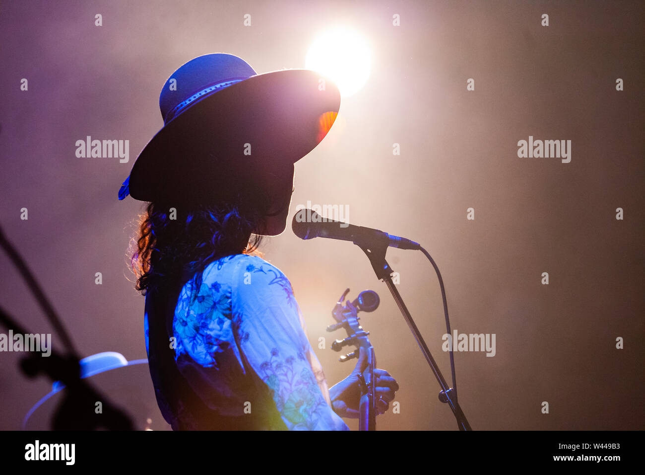 A backlit view of a female singer performing on a set with bokeh lens ...
