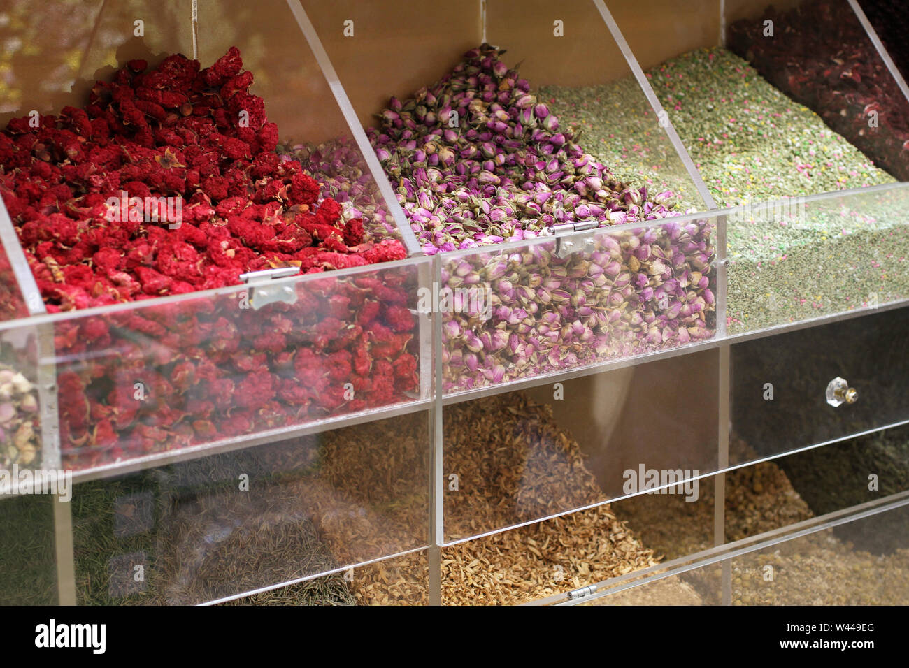 Dried herbs and flowers in transparent boxes on the counter in a street ...