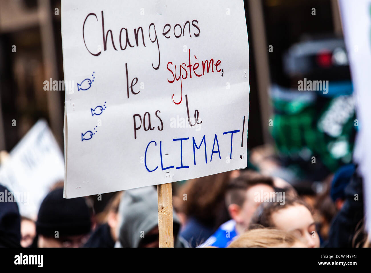 French sign reads change the system not the climate held above crowd of ...