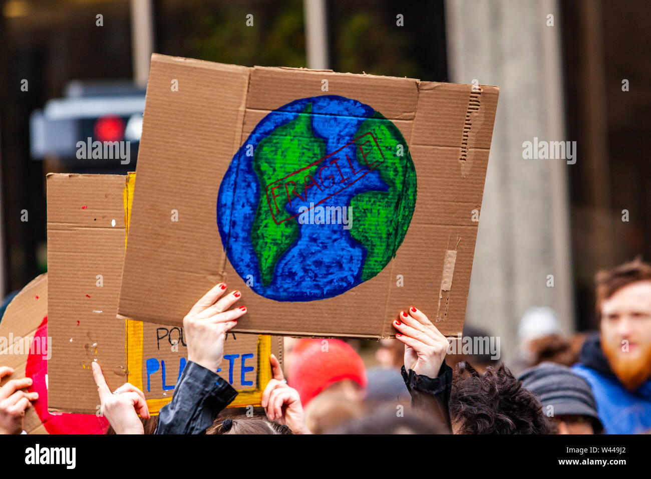 A closeup view of a cardboard sign with a hand drawn picture of planet ...