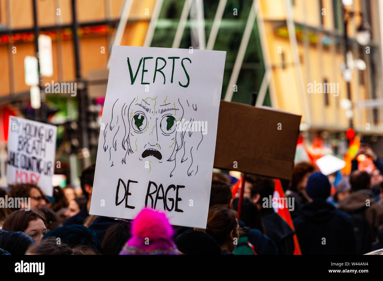 A closeup view of a French sign held by a protestor, depicting an angry ...