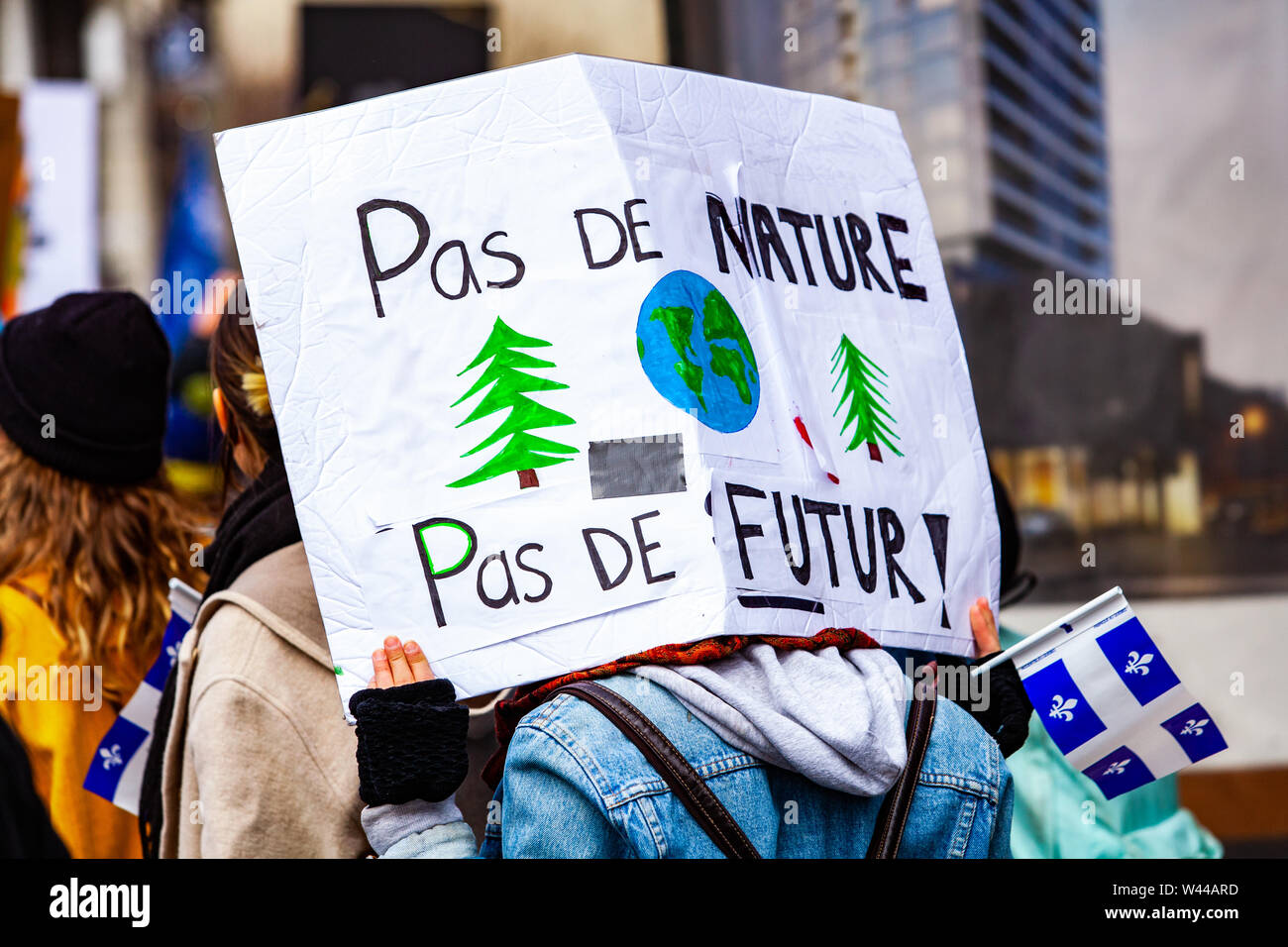 A French sign is held by an ecological activist, depicting planet earth ...