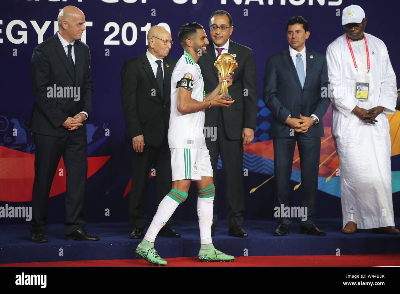 Cairo, Egypt. 19th July, 2019. Algeria's Riyad Mahrez (C) receives the trophy from FIFA ...