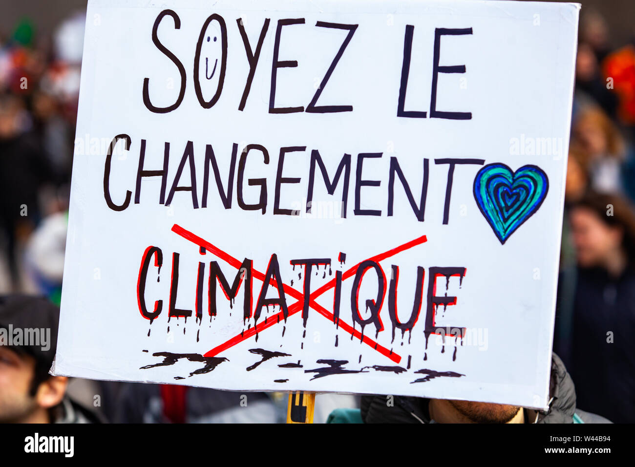 A close up view of a French poster, saying be climate change, held by ...