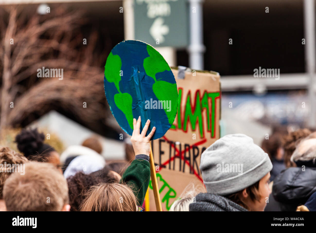 A colorful placard depicting planet earth is seen above the heads of ...