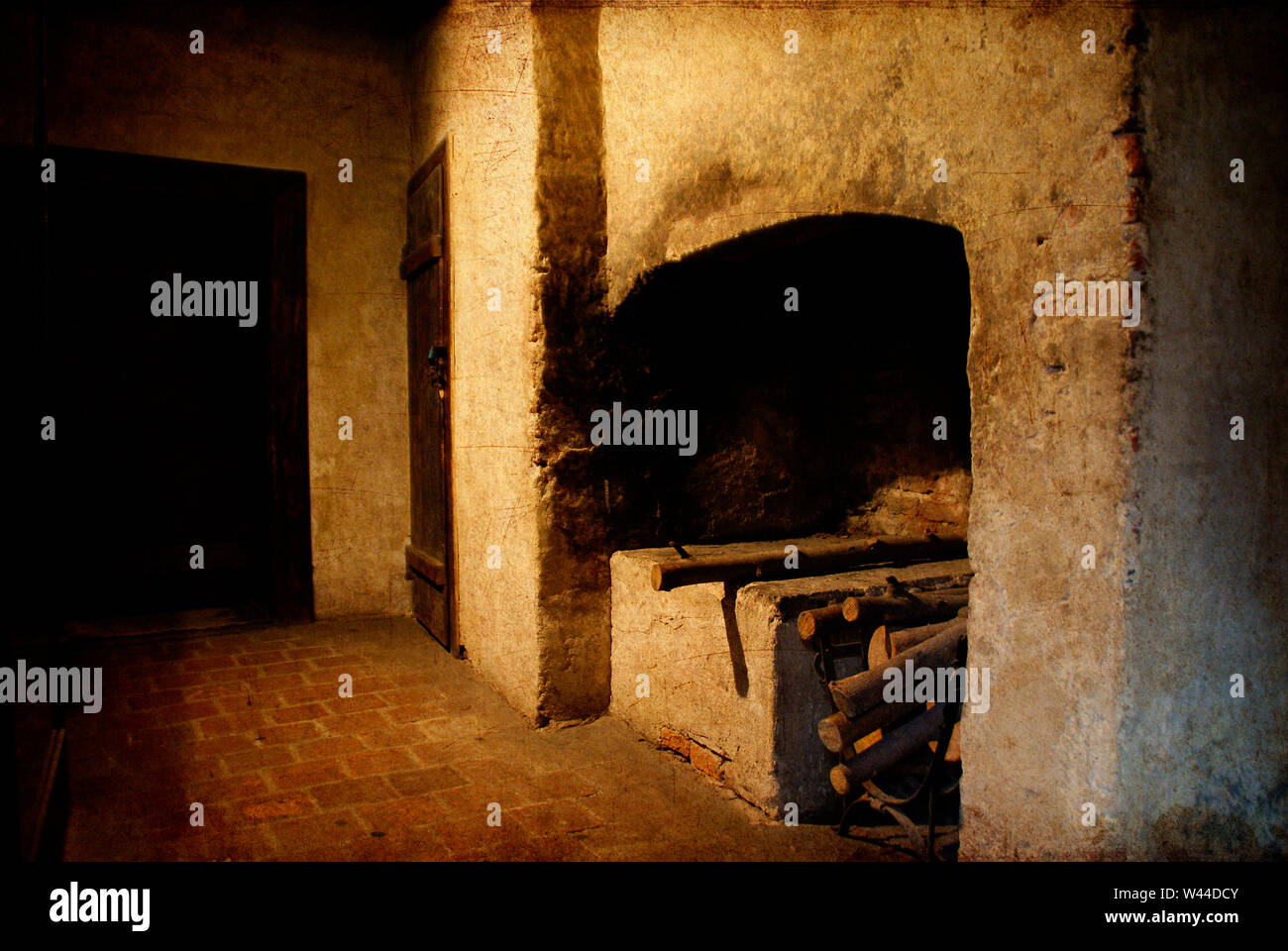 Interior of an old manor house with fireplace ready to light with logs ...