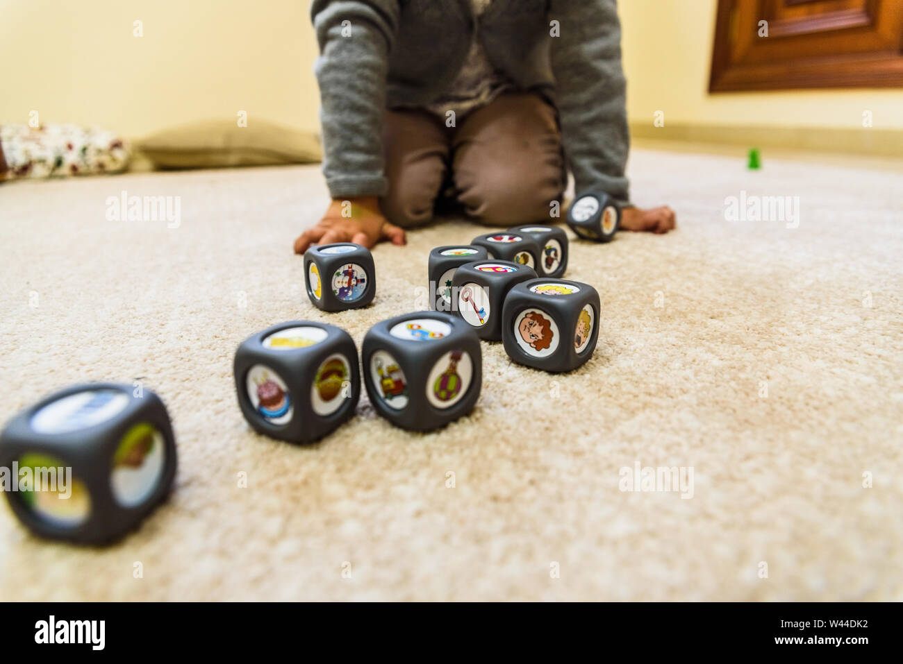 Little girl playing with a children's toy dice Stock Photo - Alamy