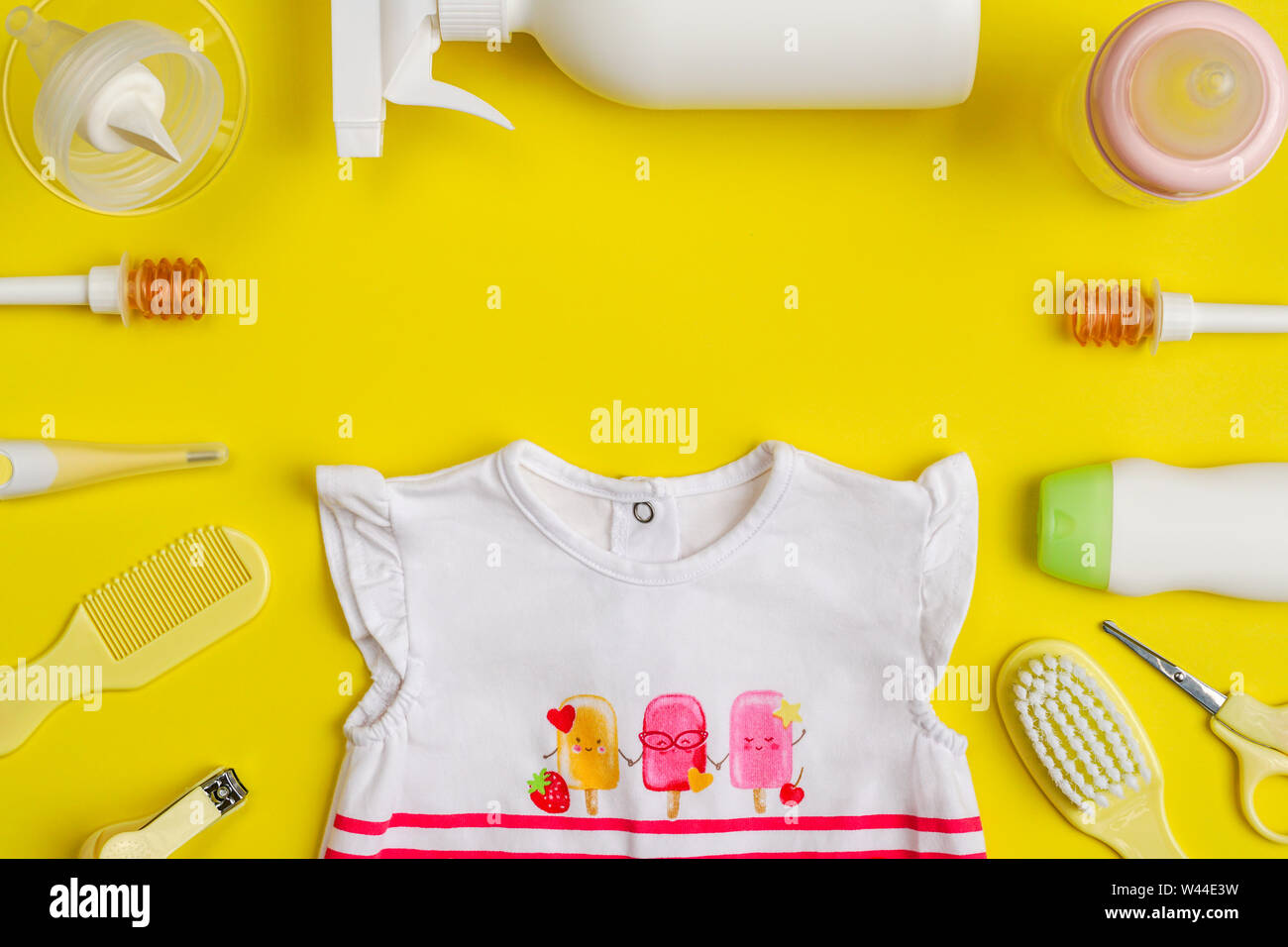 Baby care kit and clothing on yellow background Stock Photo - Alamy