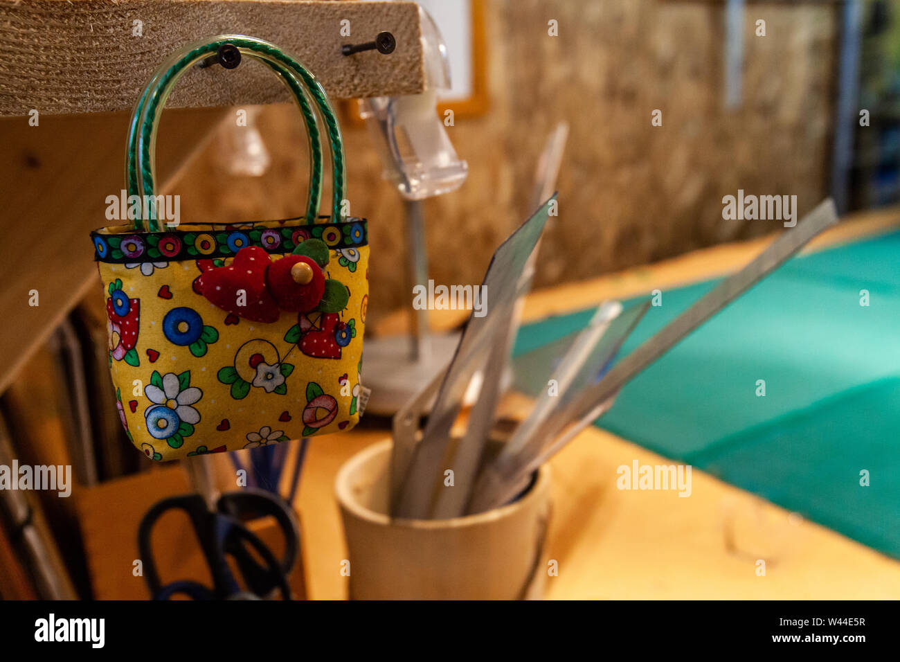 A closeup view of a small cute floral patterned bag, and measuring ...