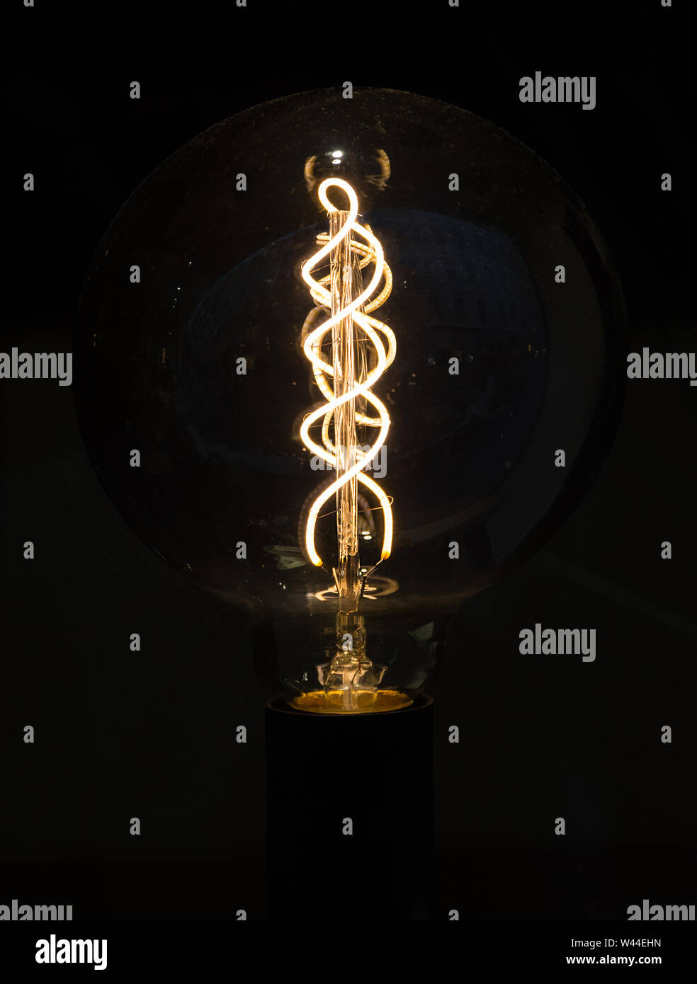 Lightbulb on dark background with bright spiral wire Stock Photo - Alamy