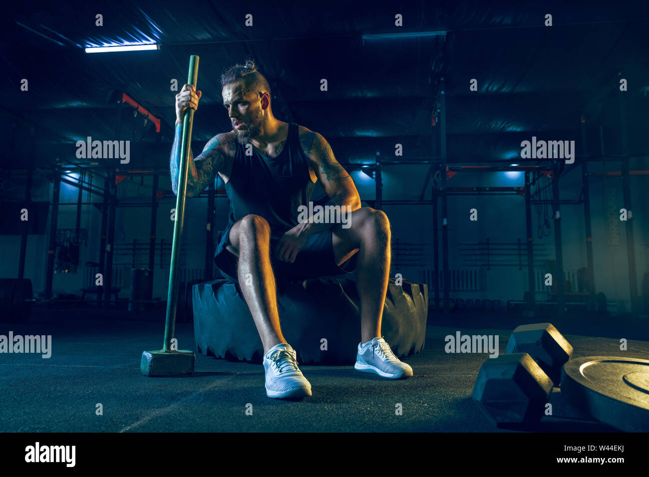 Young healthy man athlete doing exercises in the gym. Single male model ...
