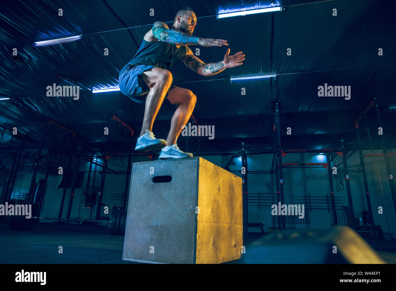 Young healthy man athlete doing exercise with the stand in the gym ...