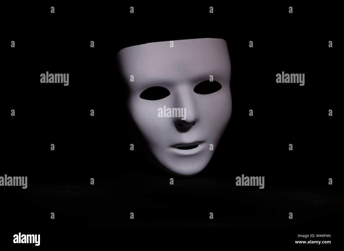 white mask on black background Stock Photo - Alamy