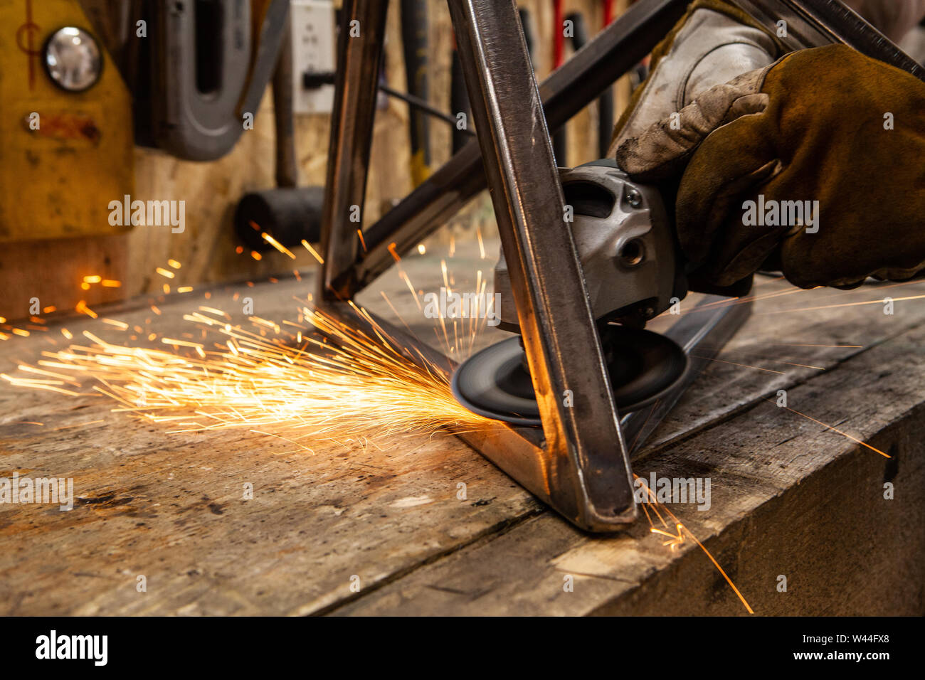A close up view of an abrasive disc cutter in use. Hands of a skilled ...