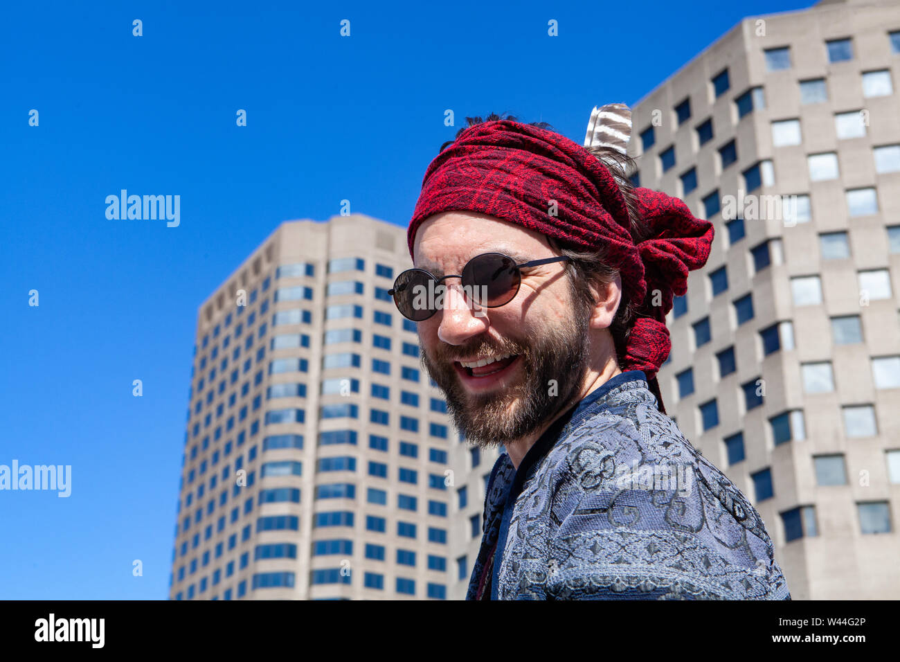 A close up portrait of a smiling shaman standing in the city center ...