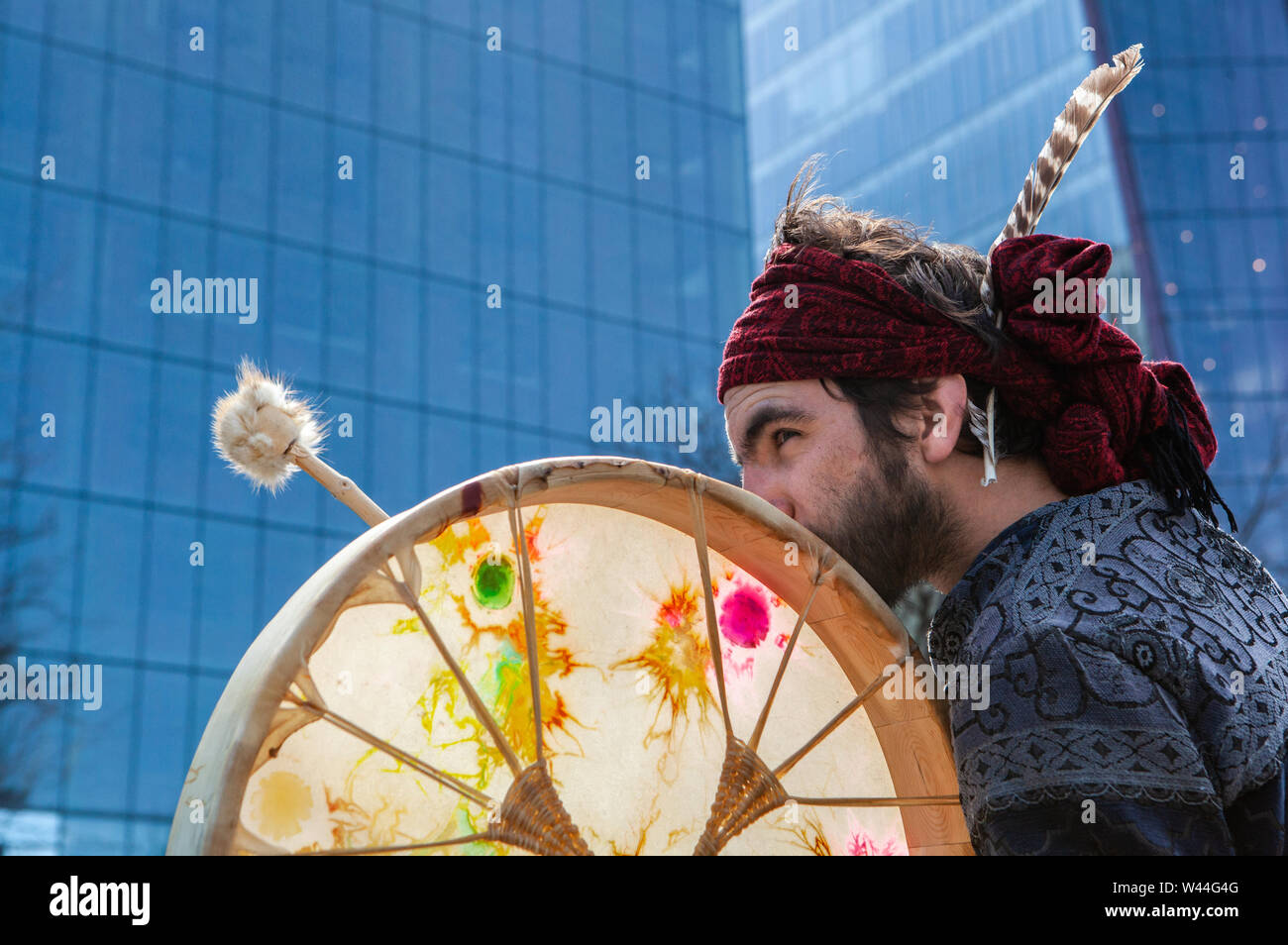A close up and side profile view of a bohemian guy holding a colorful ...