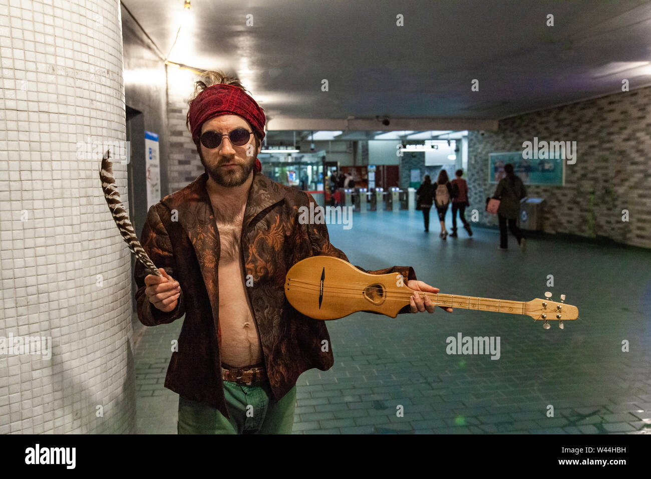 A sacred man stands in an underground tunnel with merlin guitar and ...