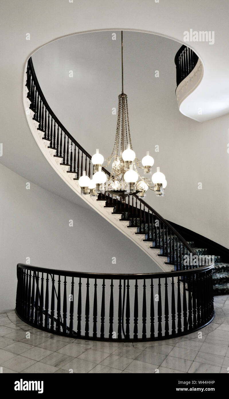 View of a Beautiful cantilevered spiral staircase with a chandlier ...