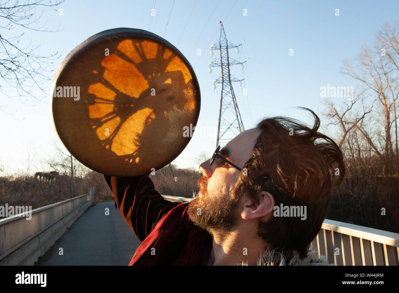 A closeup and side profile view of a shaman as he raises a Native ...