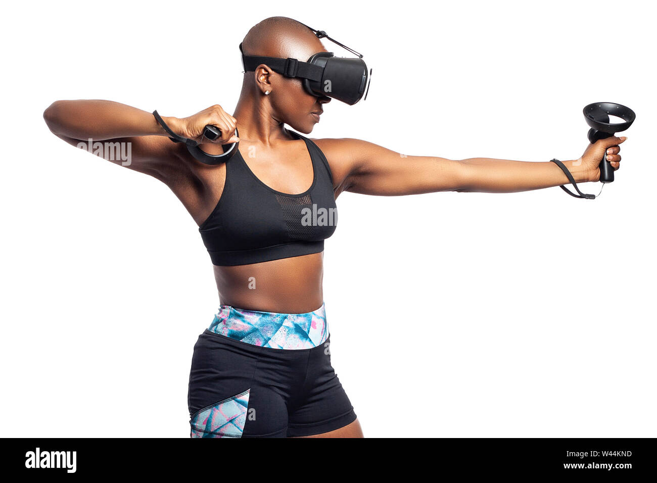 Black female wearing virtual reality headset pretending to draw a bow ...