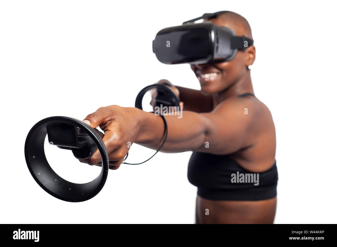 Black female gamer holding virtual reality controllers or wands and ...