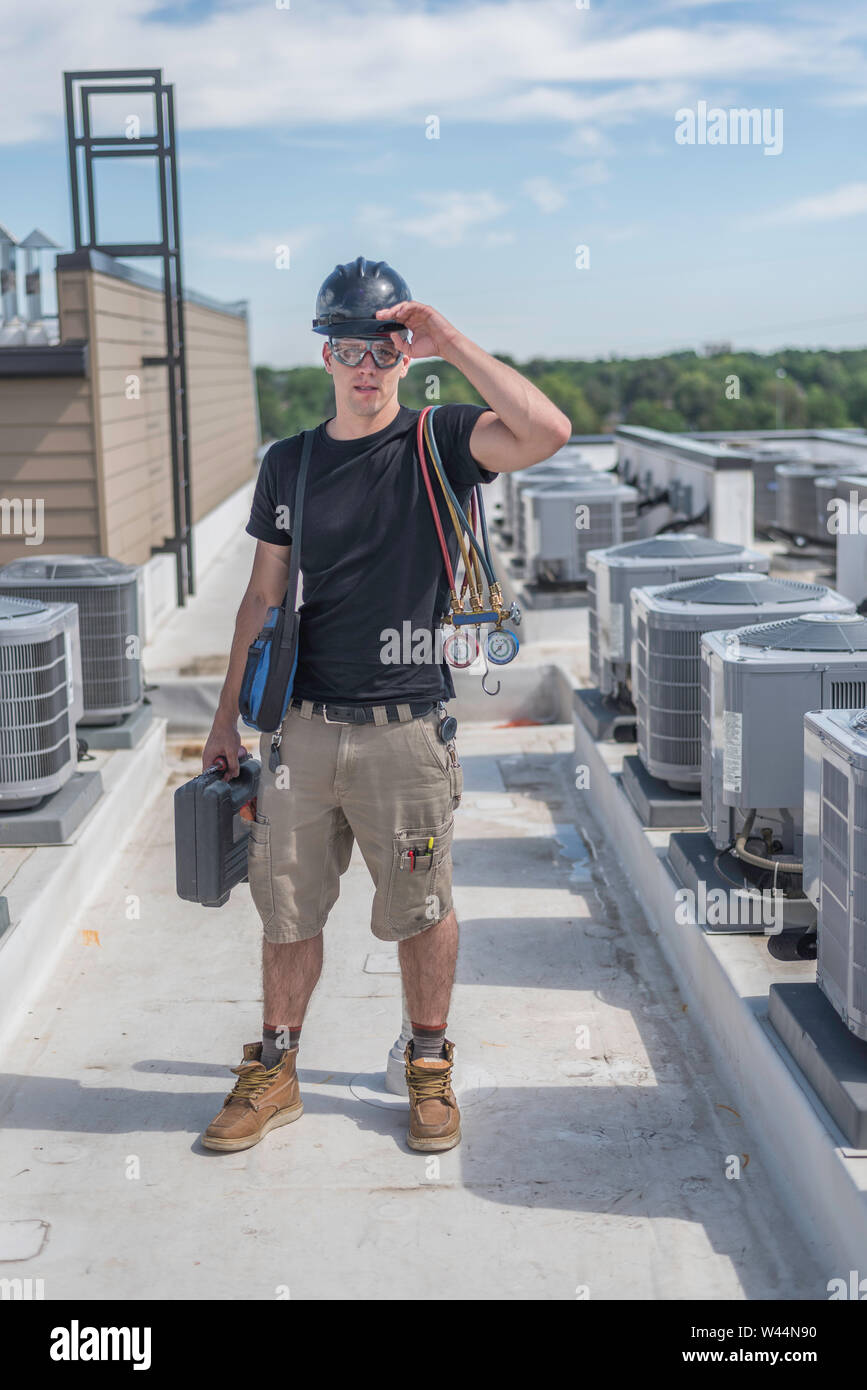 Hvac tech with hardhat, safety glasses and hvac tools on a roof ...