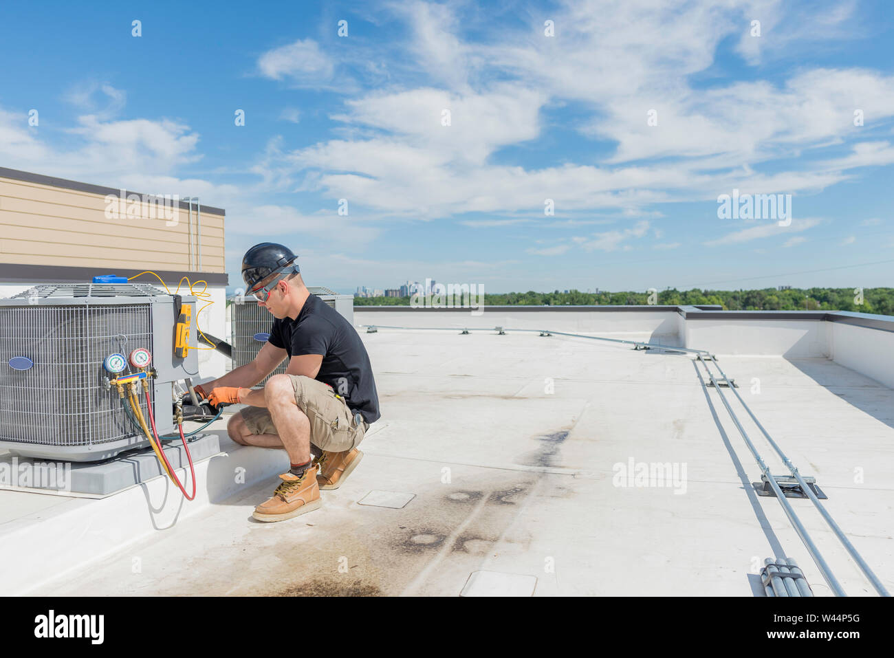 Hvac technician working on an air conditioning unit with lots of open ...