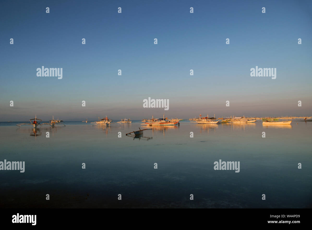 Sunrise on the beach with banca boats and fisherman at Panglao Island ...