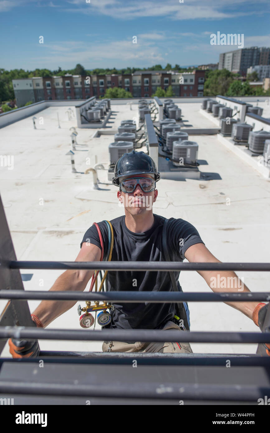 Hvac tech on a ladder, with rows of condensers in the background Stock ...