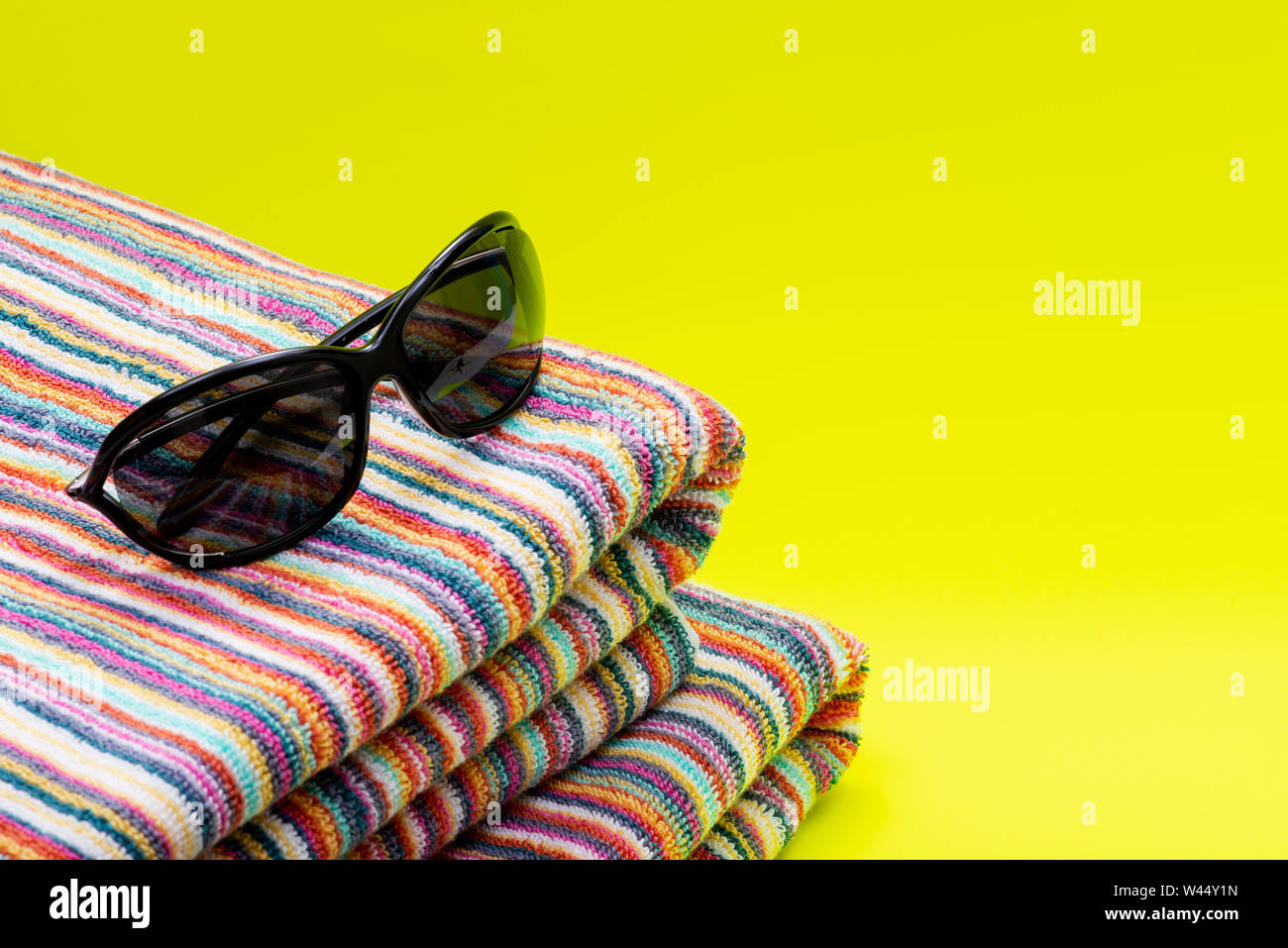 Folded Colorful Striped Organic Cotton Beach Towels and black ...