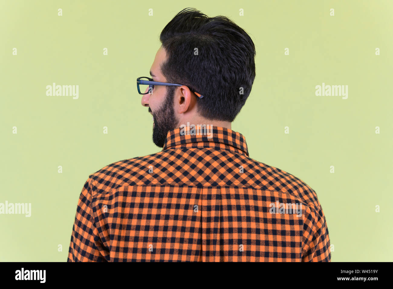 Closeup rear view of happy young bearded Persian hipster man smiling ...