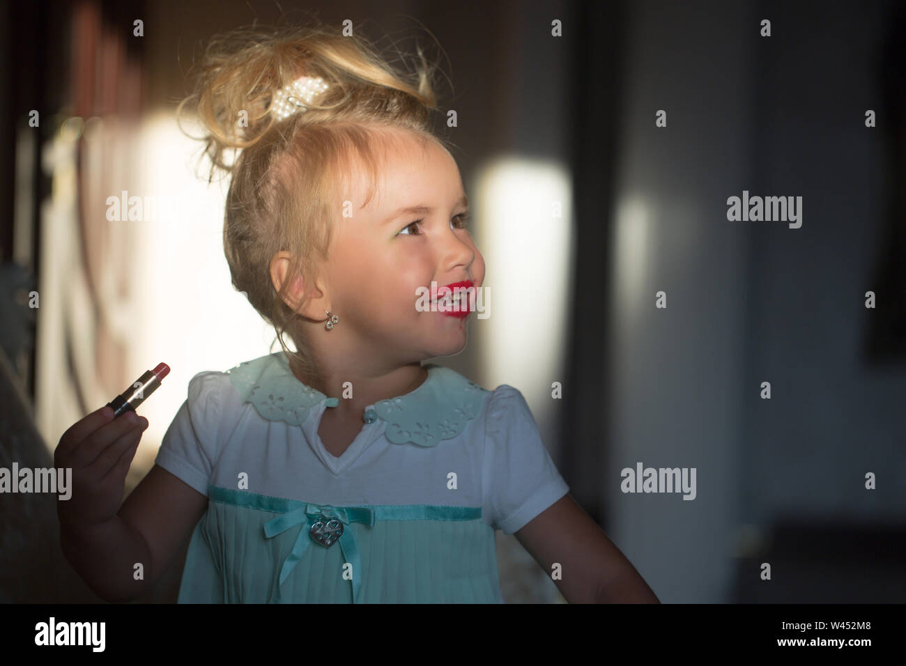 Girl child smile with red lips makeup and lipstick in room. Happy ...