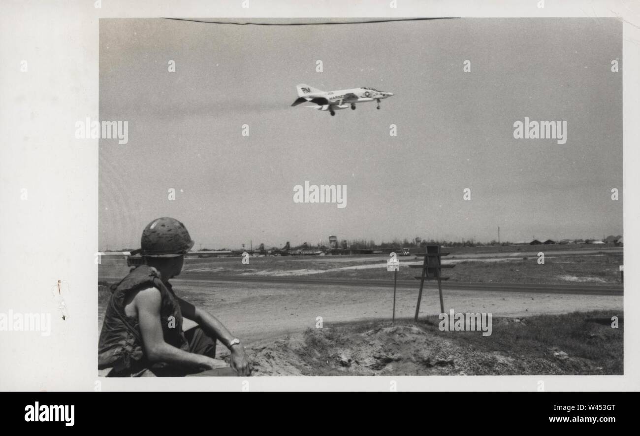 Company C, 1st Military Police Battalion Marine watches an F-4 land at ...