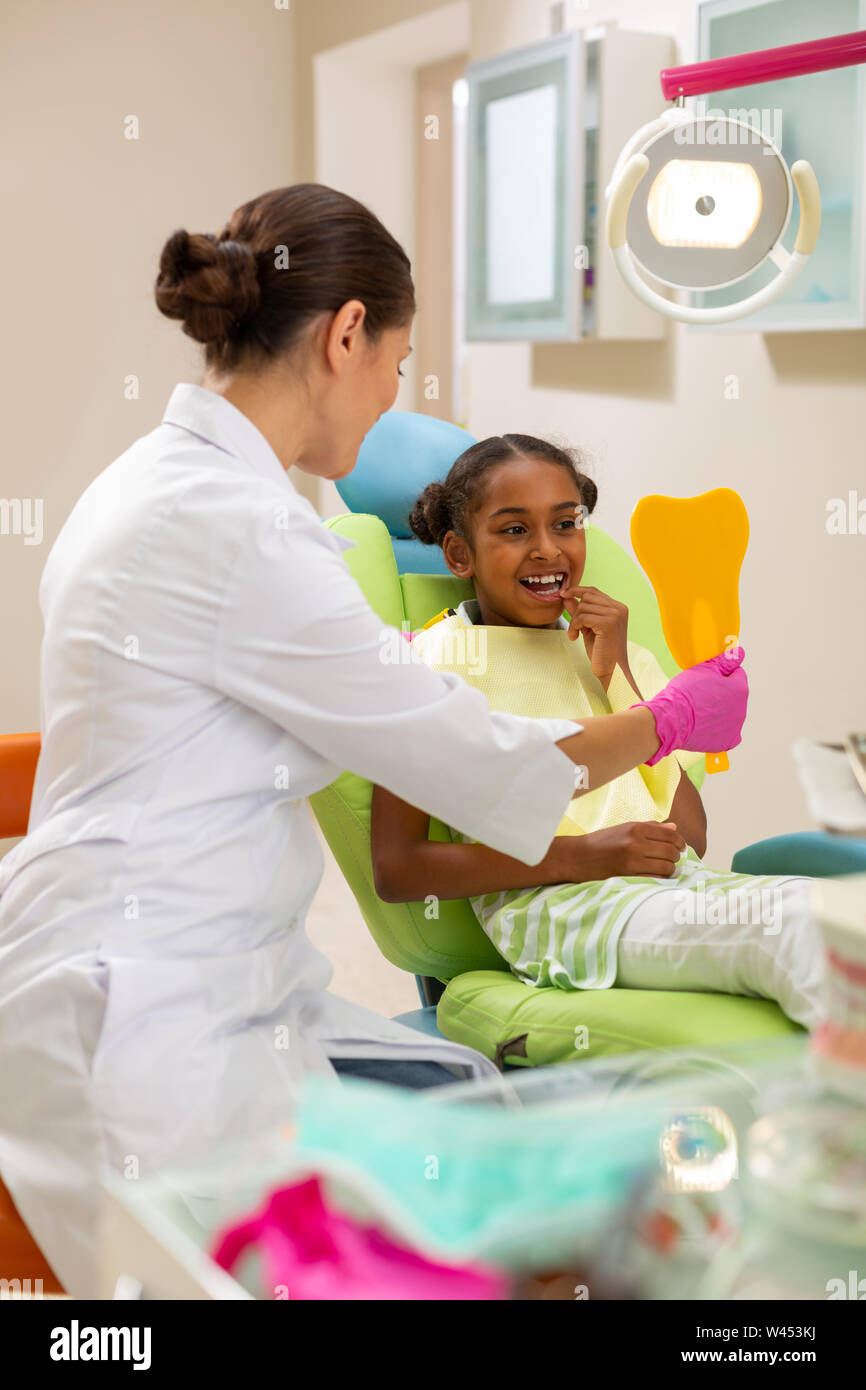 Dark-haired Caucasian woman doctor holding a yellow mirror Stock Photo ...