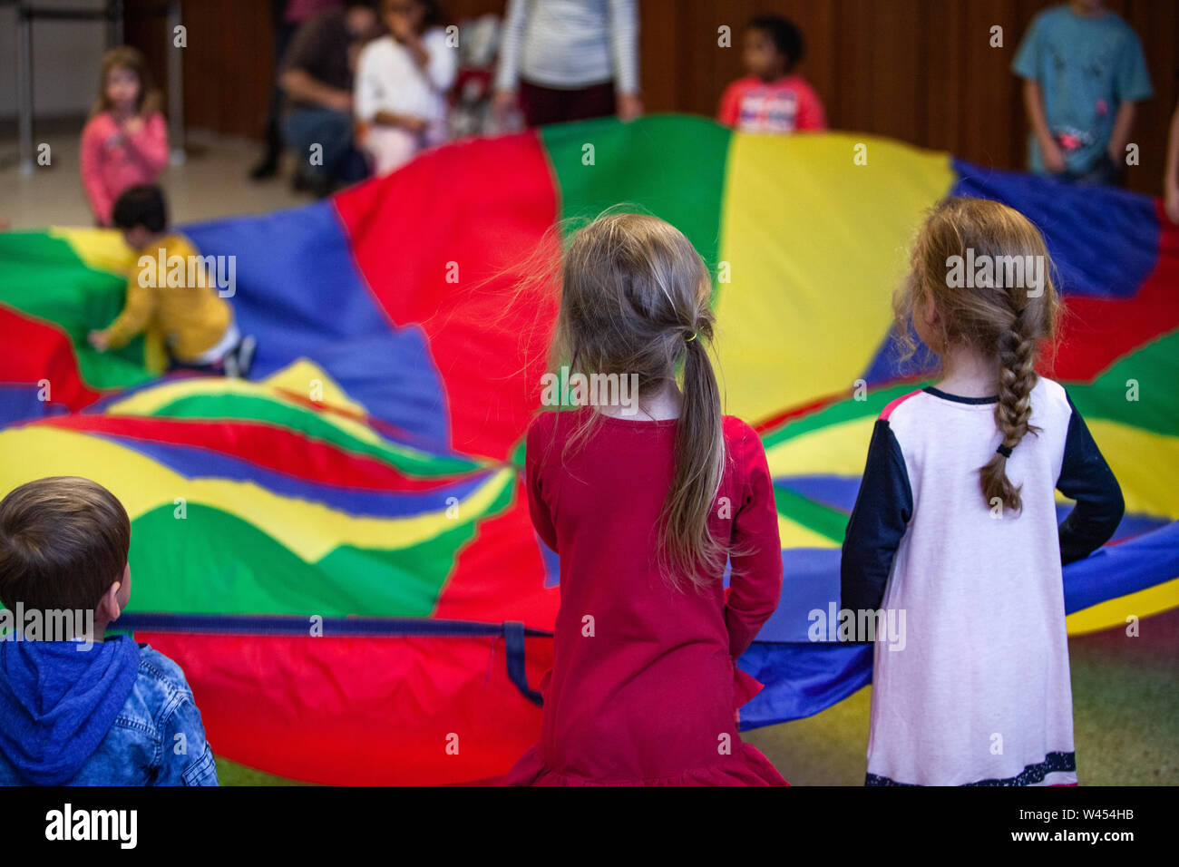 A high angled view of a group of preschool kids, playing cat and mouse ...