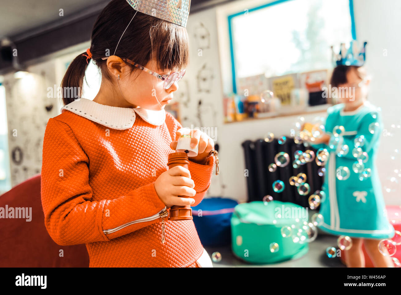 Excited ladies with down syndrome wearing pretty bright dresses and ...