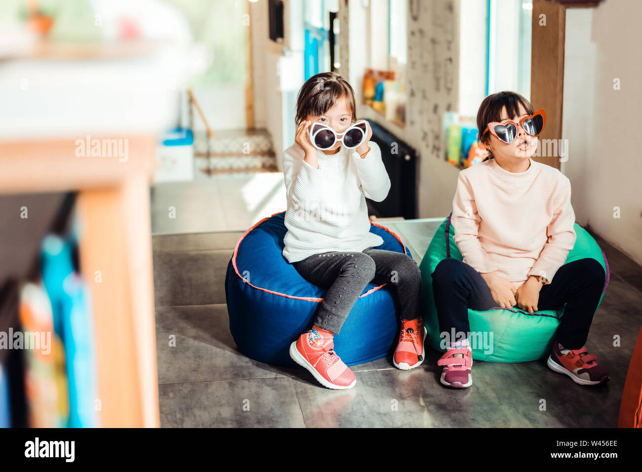 Calm young children sitting together on the armchairs Stock Photo - Alamy