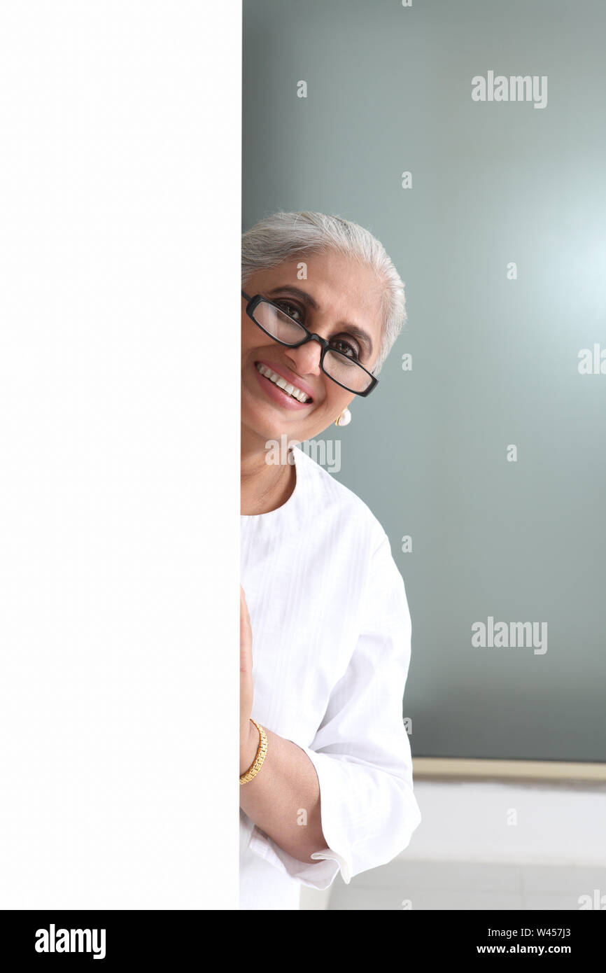 Woman hiding behind wall a watching hi-res stock photography and images ...
