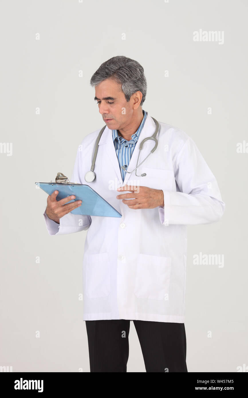 Doctor reading a medical report Stock Photo - Alamy