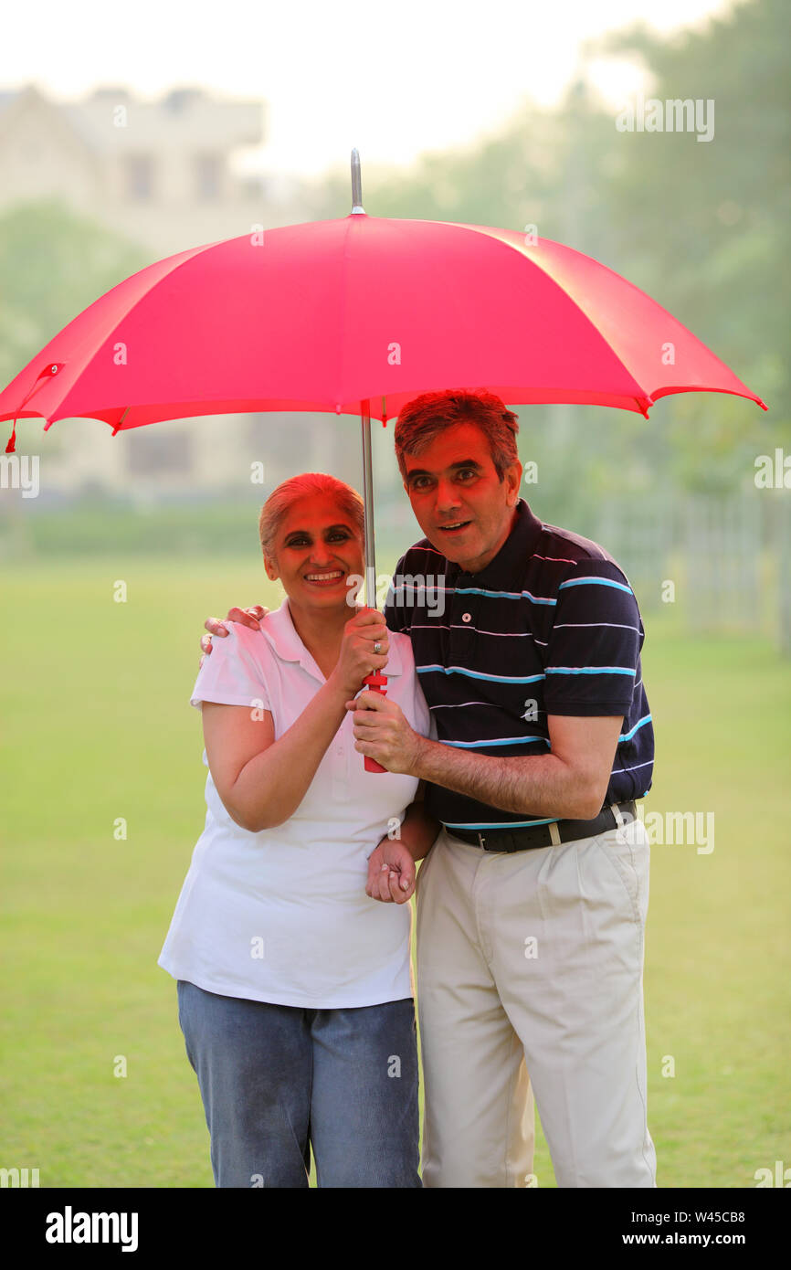 Couple sharing an umbrella Stock Photo - Alamy