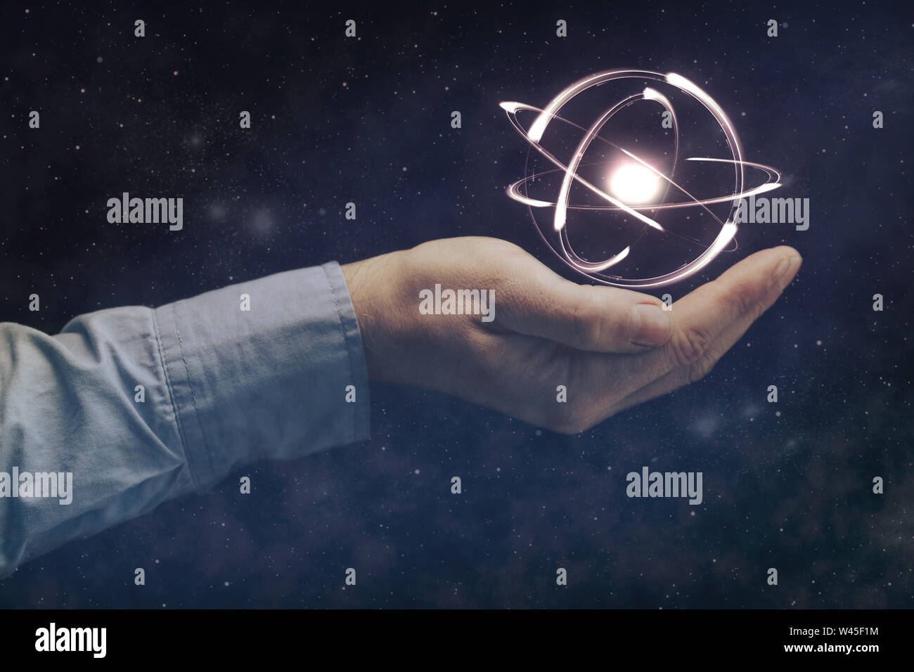 Human hand holding atom. Nebula dust. Mixed media Stock Photo - Alamy